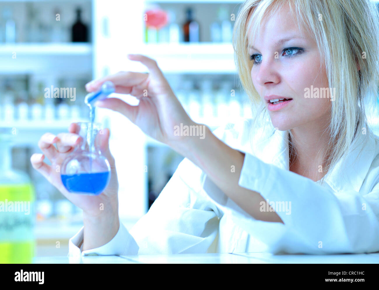 Closeup of a female researcher holding up a test tube and a retort and ...