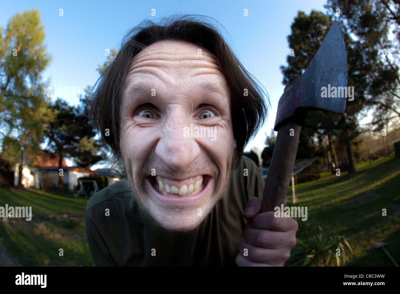 Man with a mad facial expression holding an axe Stock Photo - Alamy