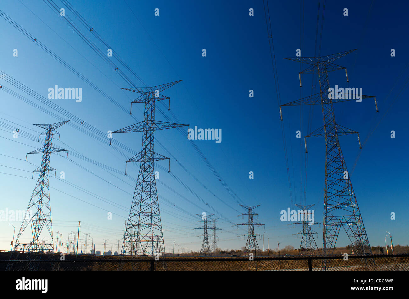 Power lines against blue sky Stock Photo - Alamy