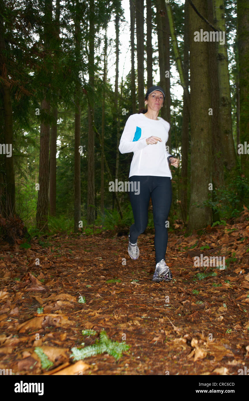 Woman running in forest Stock Photo - Alamy