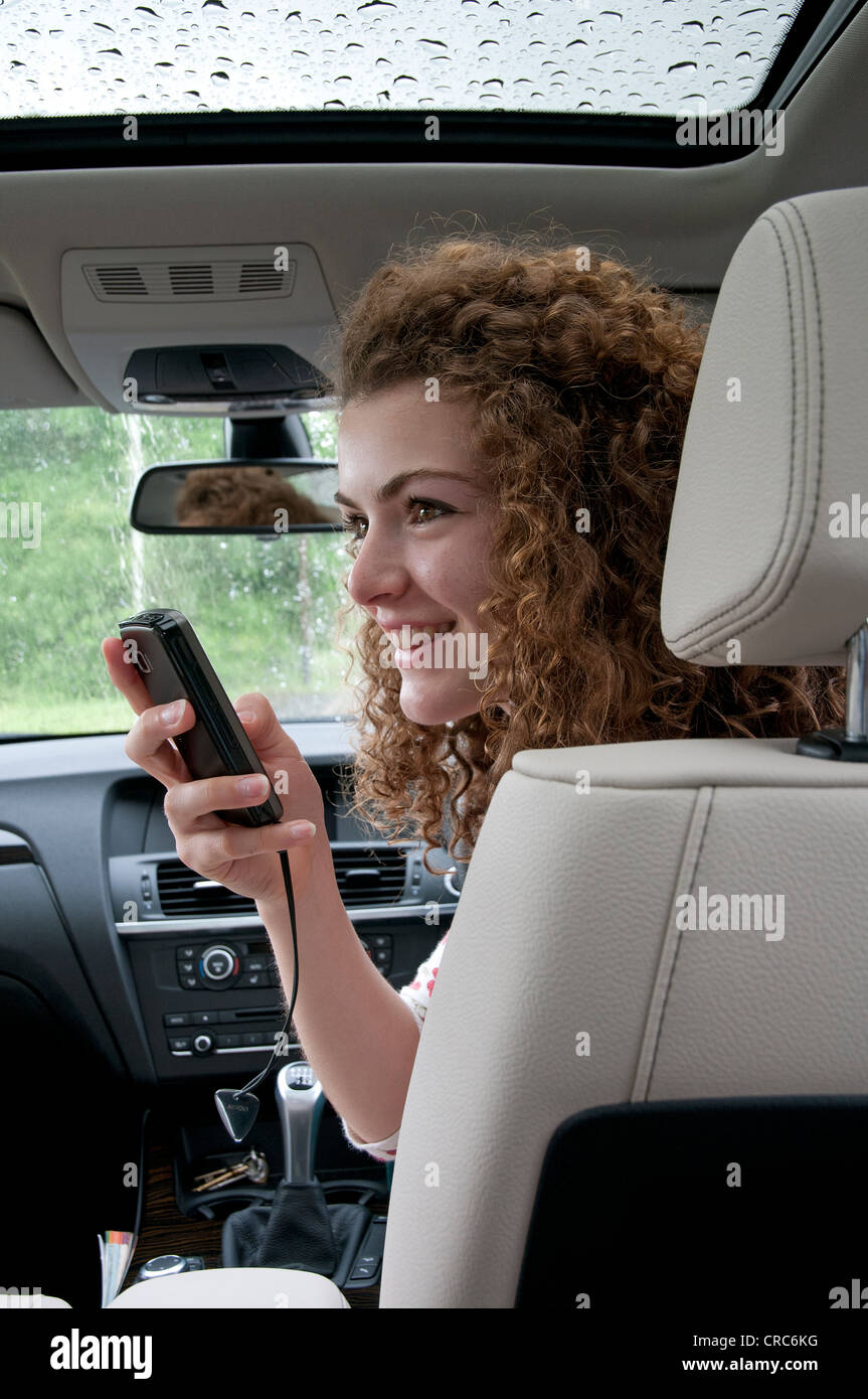 Young female driver using a mobile phone to send text message Stock ...