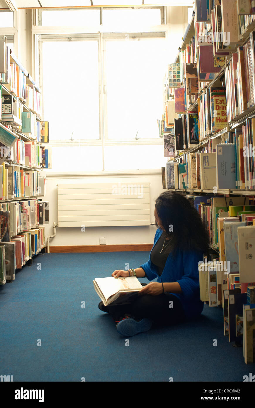 Student reading in library Stock Photo - Alamy