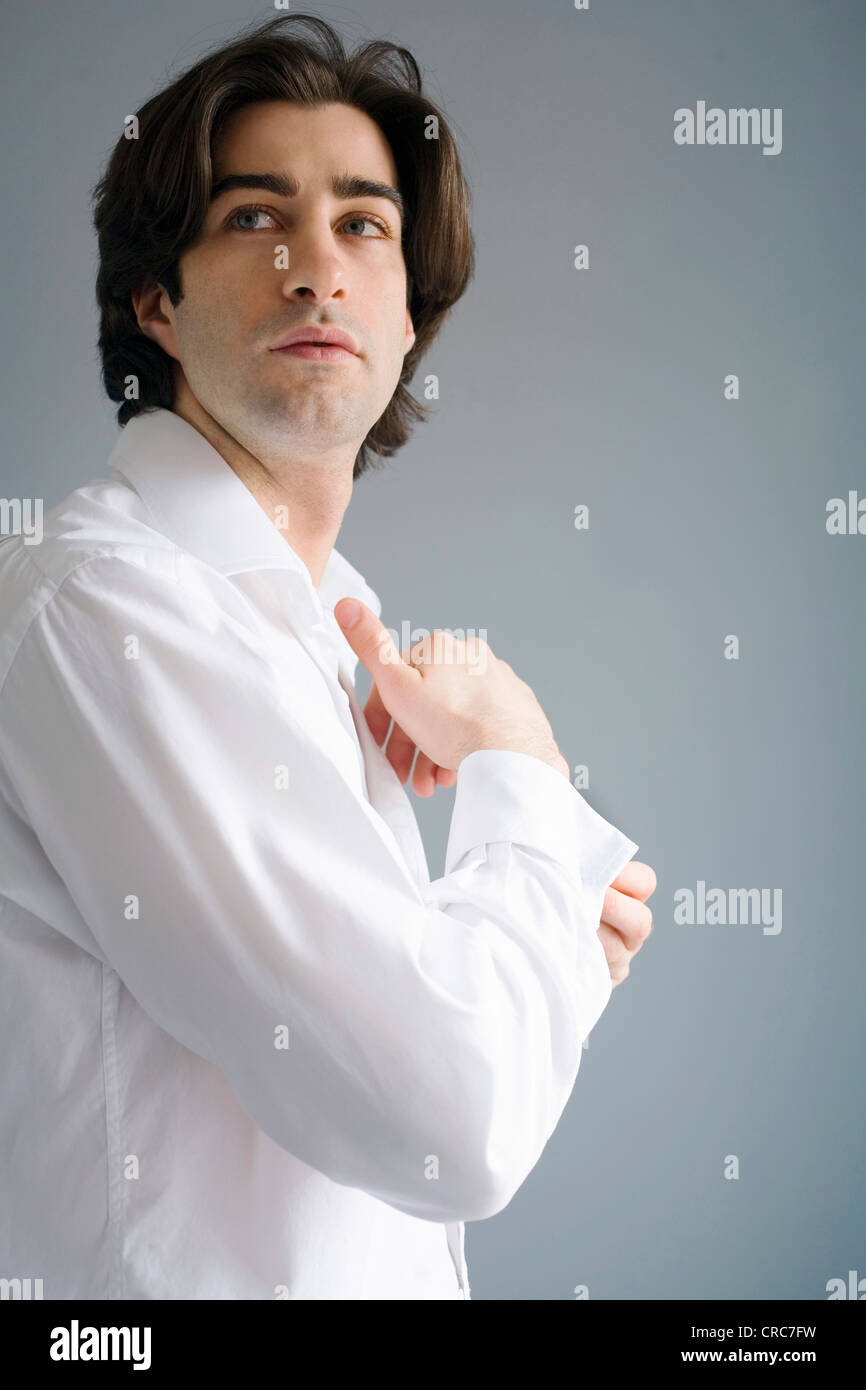 Businessman buttoning his cuffs Stock Photo - Alamy