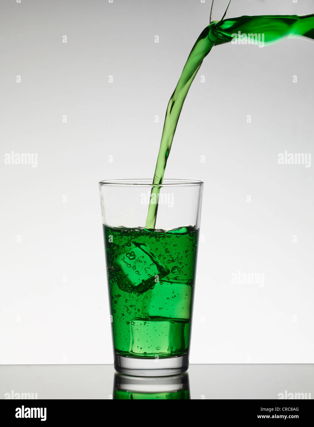 Juice pouring over ice in glass Stock Photo - Alamy