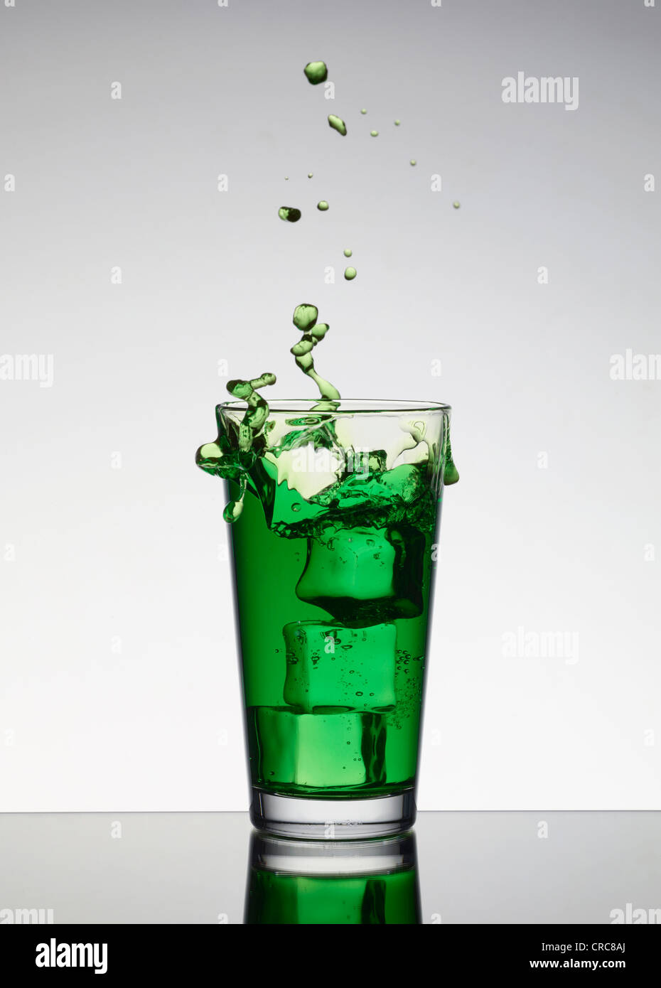 Ice falling into glass of juice Stock Photo - Alamy