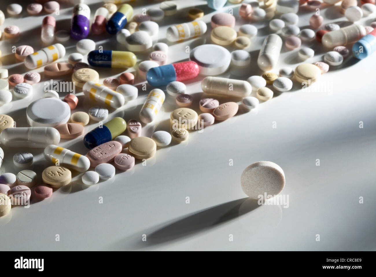 Pills scattered on reflective surface Stock Photo - Alamy