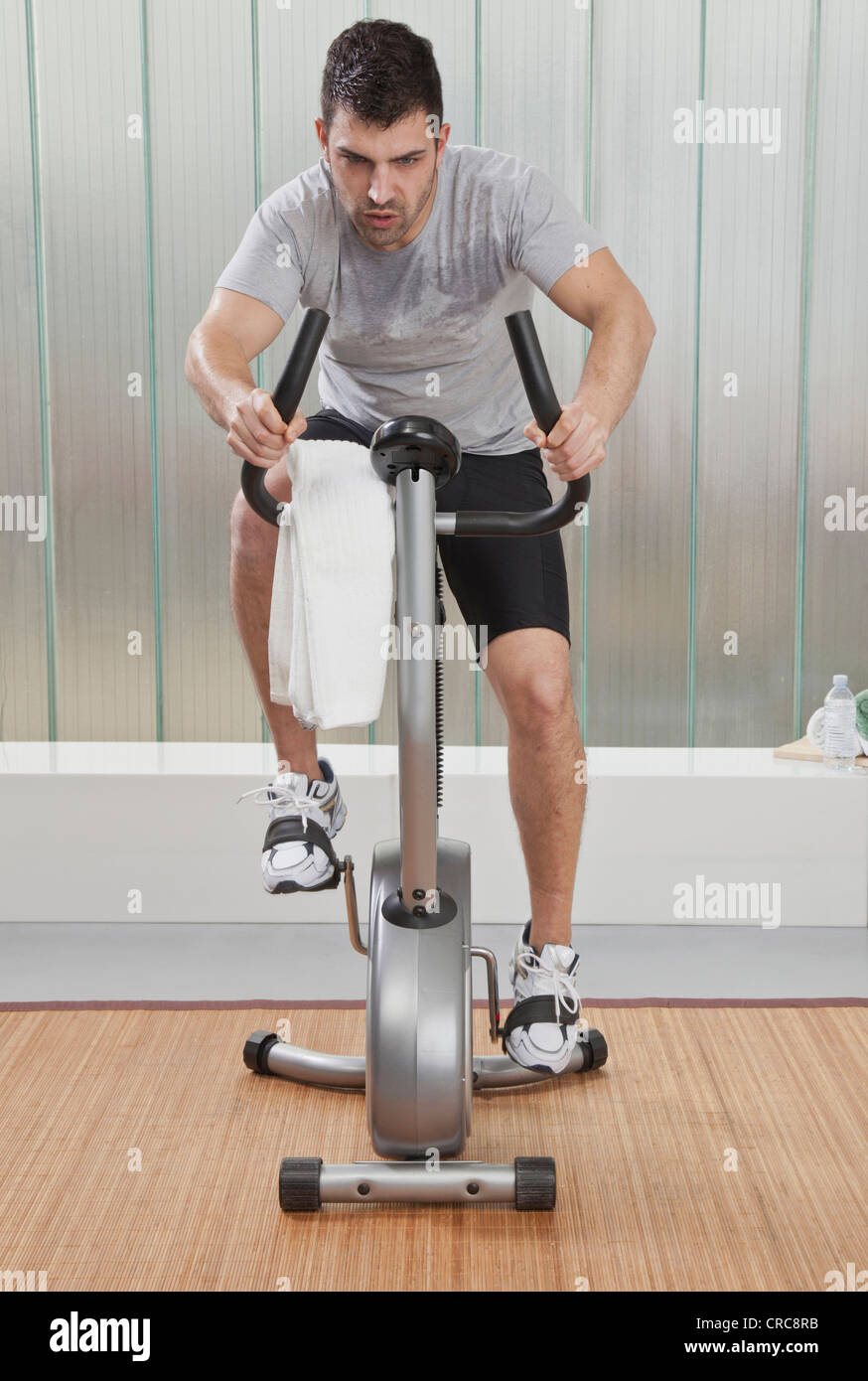 Struggling man using exercise machine Stock Photo - Alamy