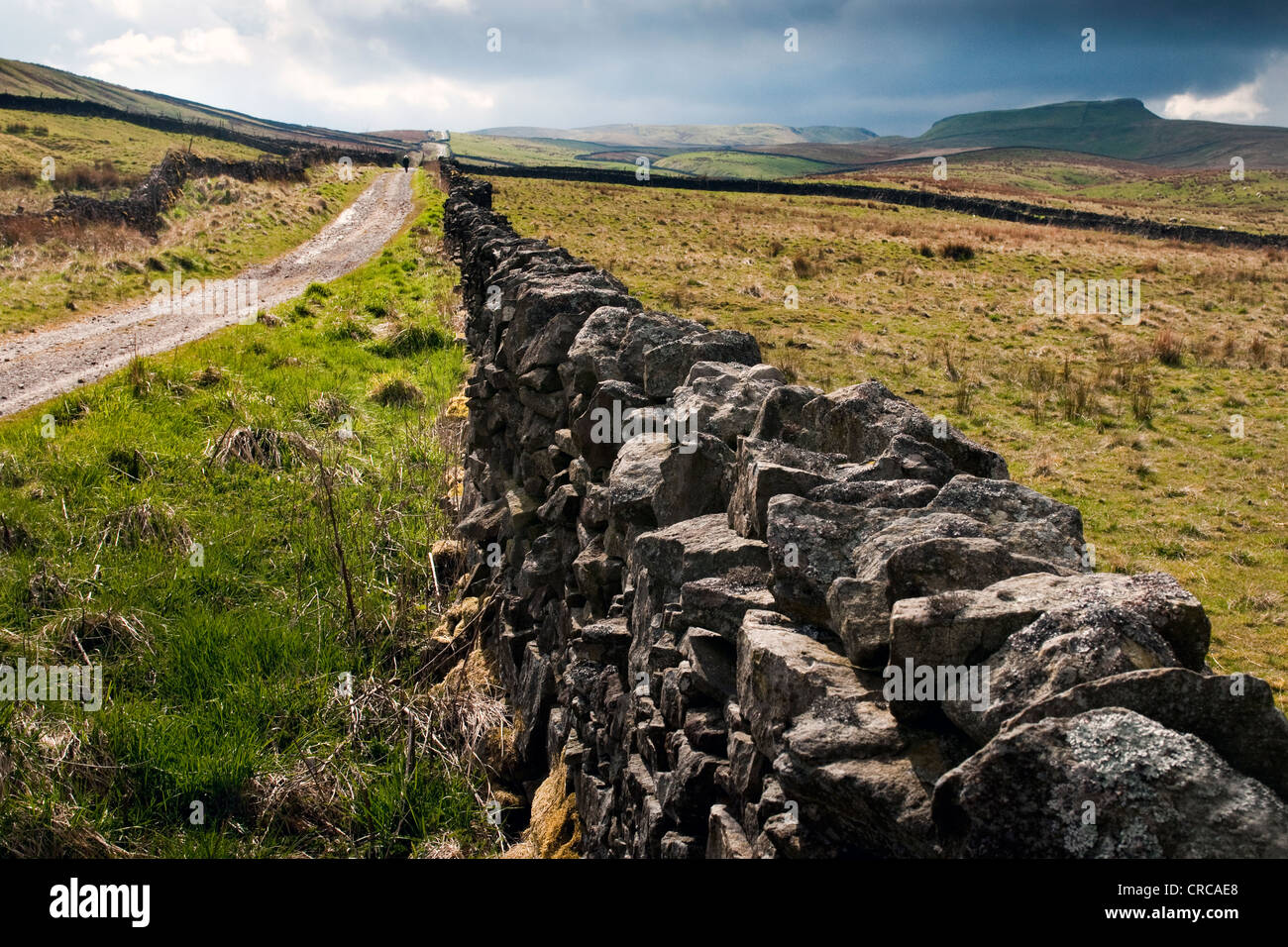 A drystone wall and the roman road lead towards a storm over Yorburgh ...