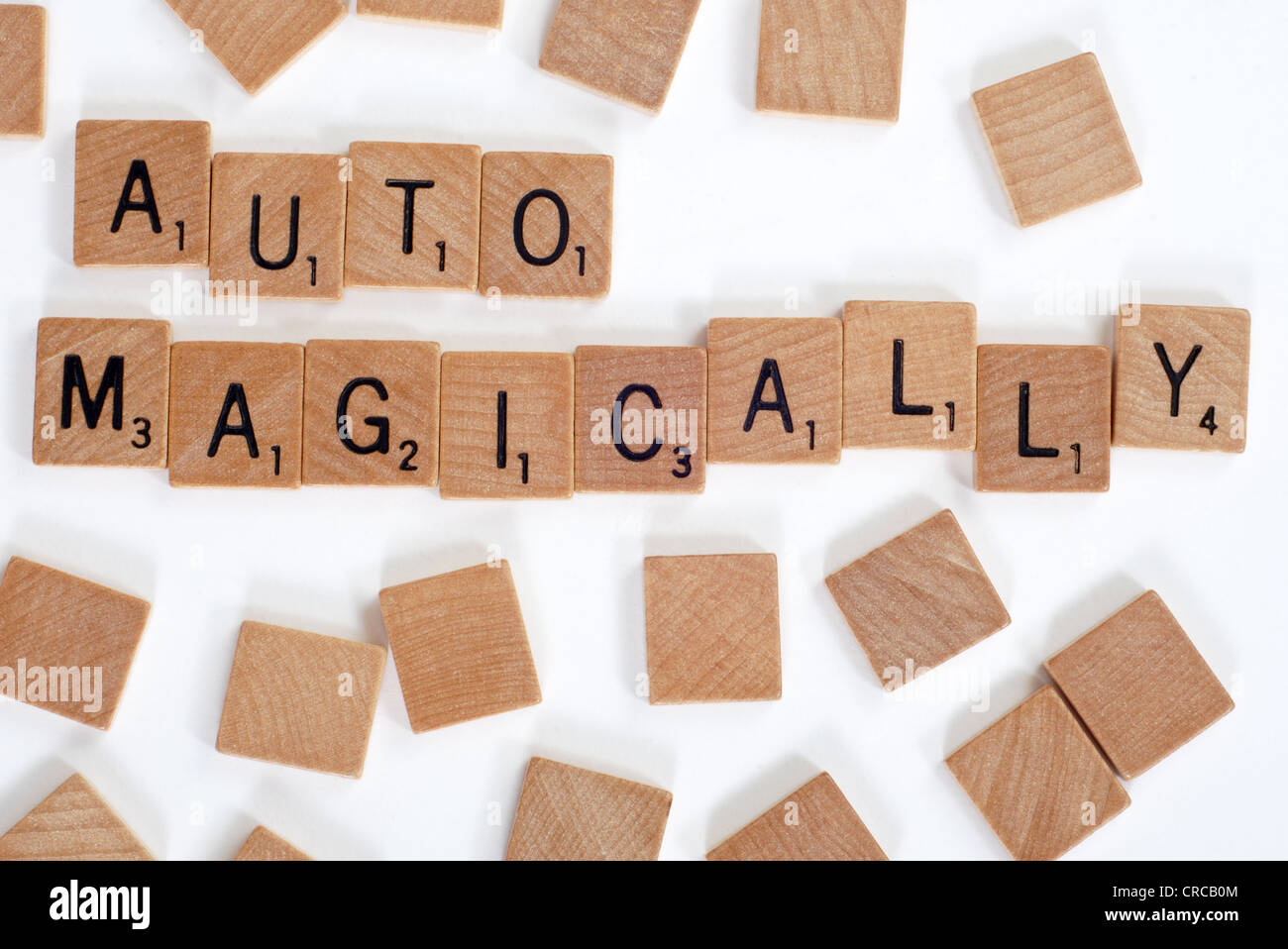 Wood Scrabble tiles spelling out the words 'Automagically'. On white ...