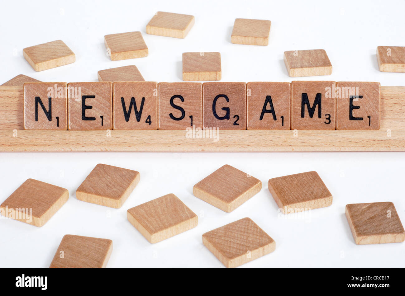 Wood Scrabble tiles spelling out the words 'Newsgame'. On white Stock ...
