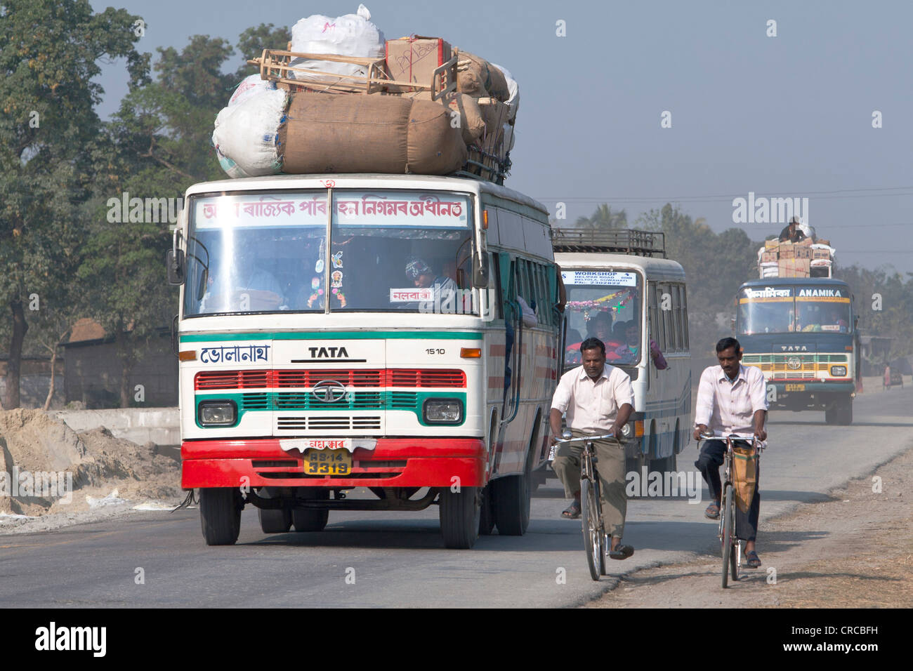 Trucks, buses and cyclists share a crowded highway, Barpeta, Assam ...