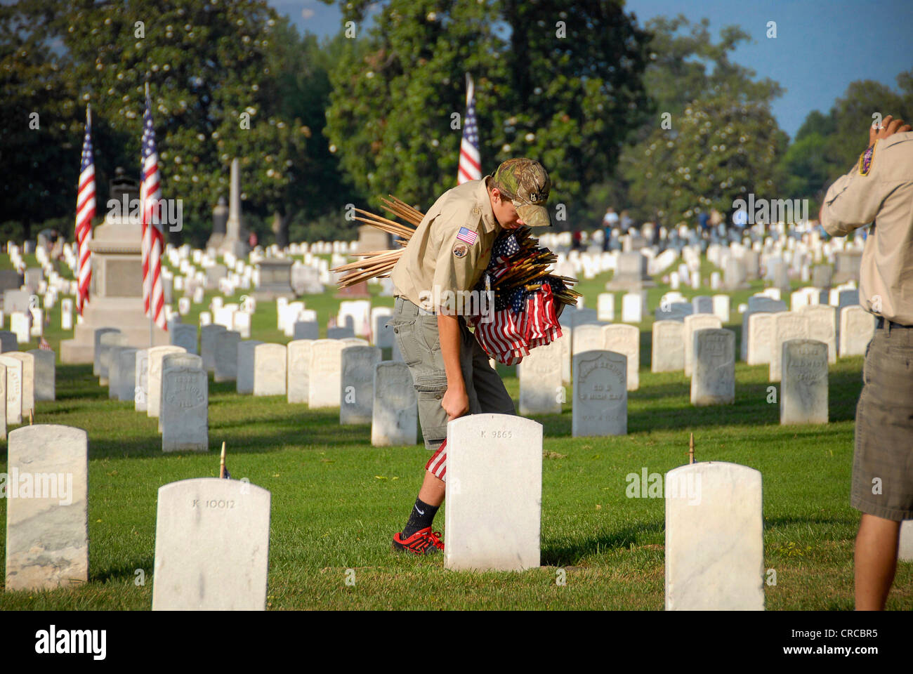 Boy Scout placing American flags at Chattanooga National Cemetery ...