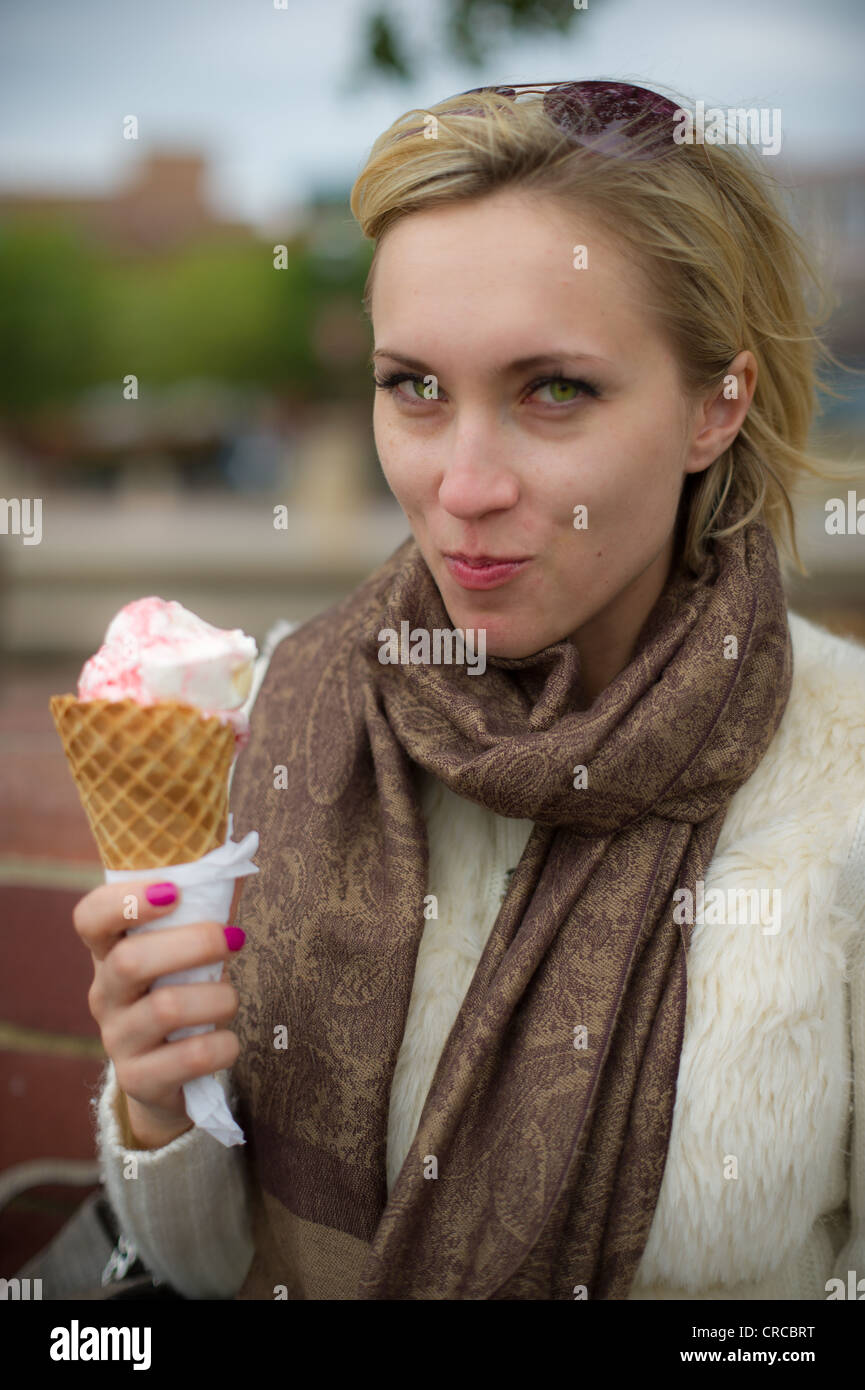 Blonde woman eating ice cream in cold weather Stock Photo - Alamy