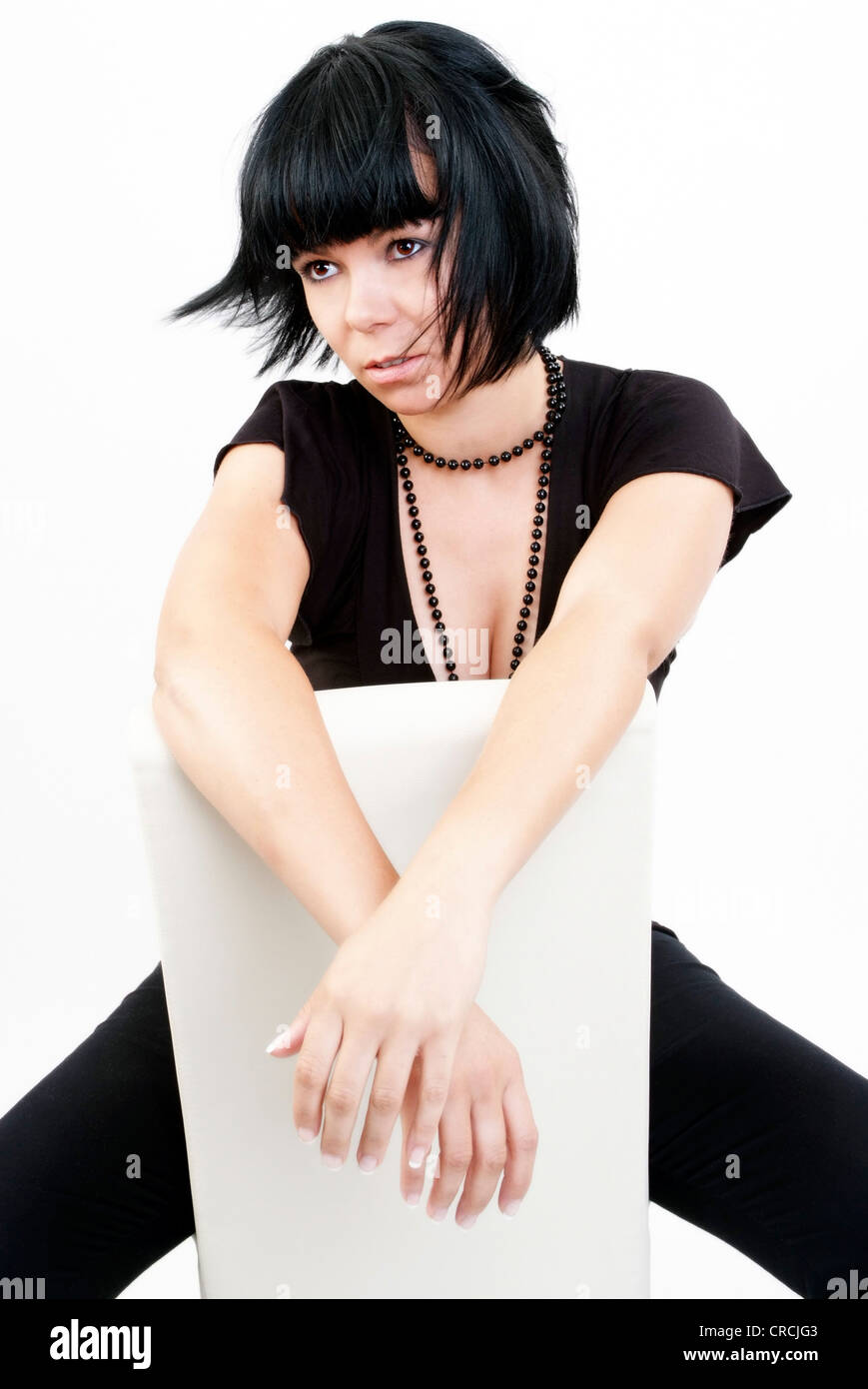 cute black-haired woman sitting on a chair Stock Photo - Alamy