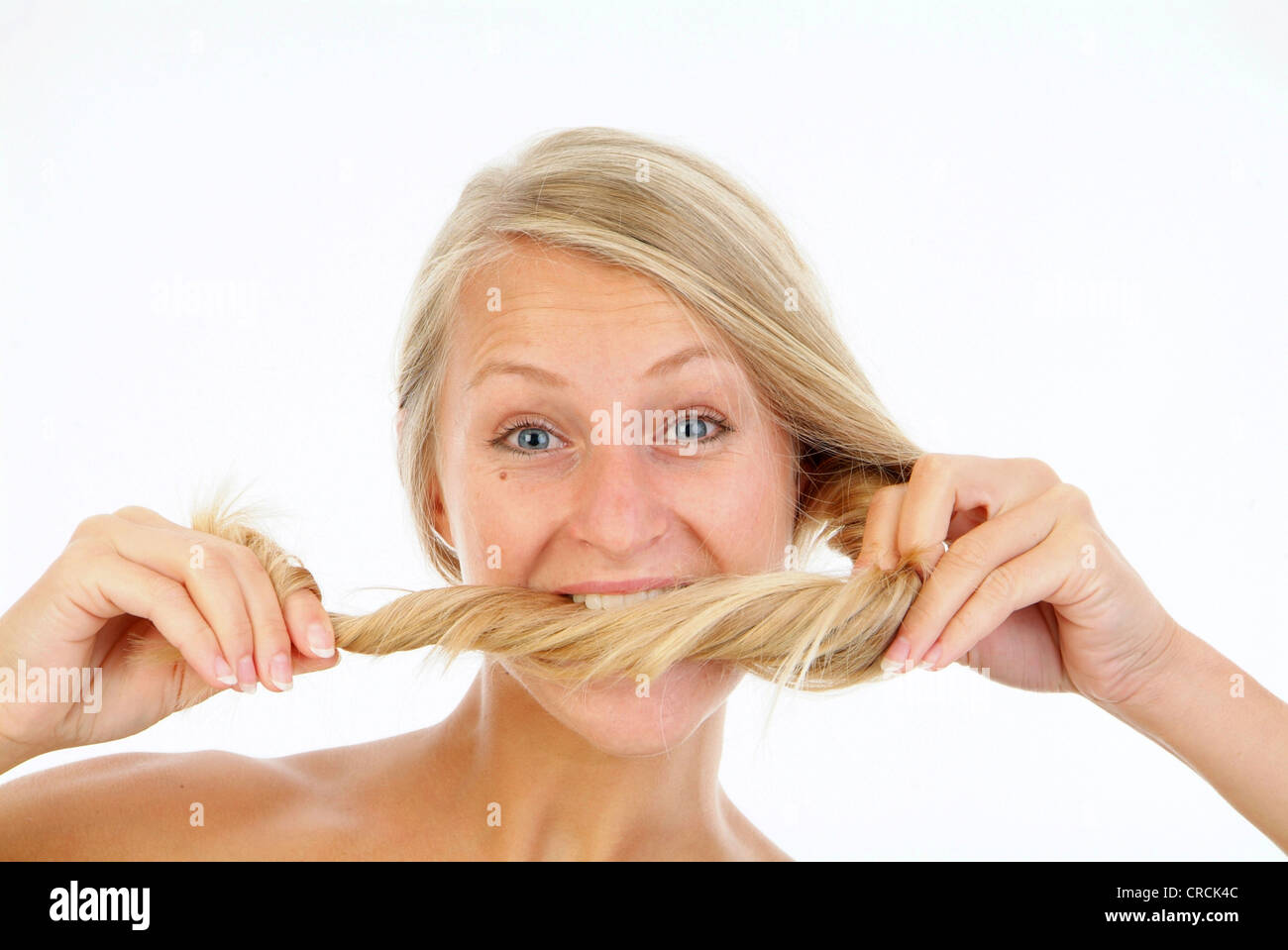 young blond woman biting in her hair Stock Photo - Alamy