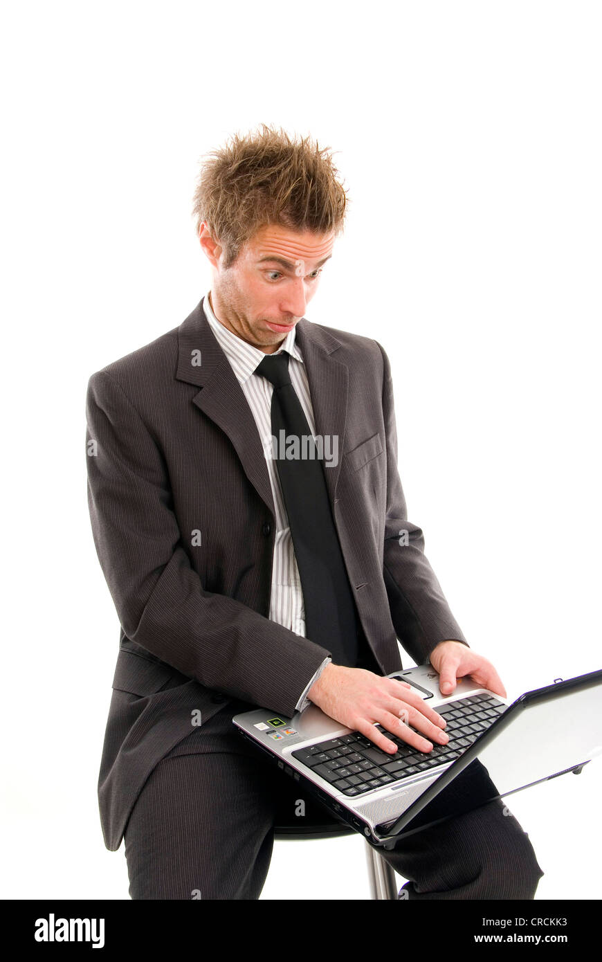 young businessman using a laptop, looking puzzled Stock Photo - Alamy
