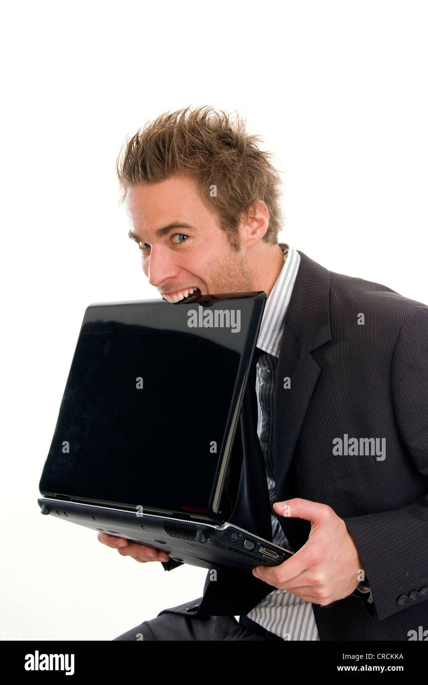 young businessman bites in laptop Stock Photo - Alamy