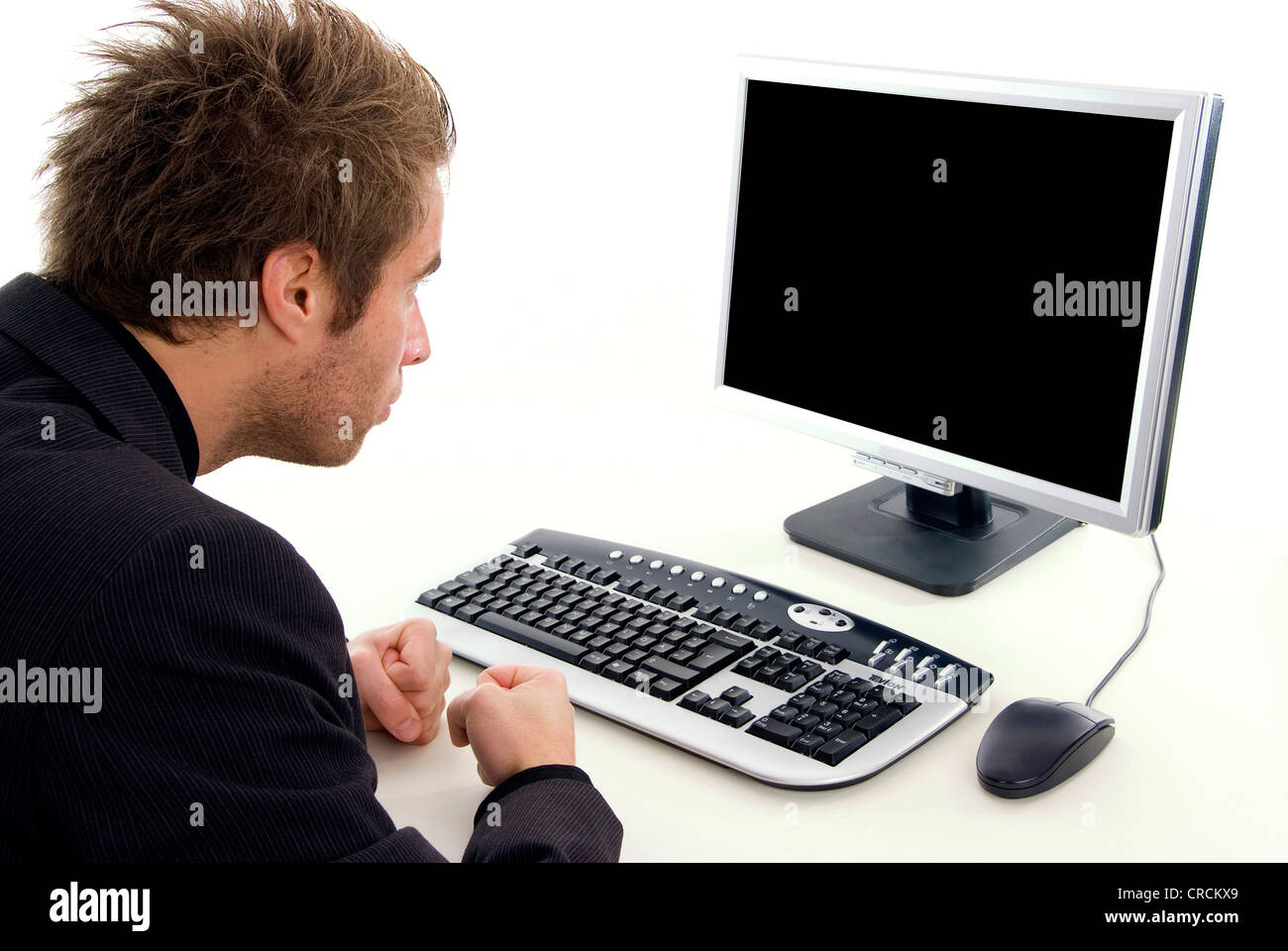 man sitting at a desk in front of a black screen Stock Photo - Alamy