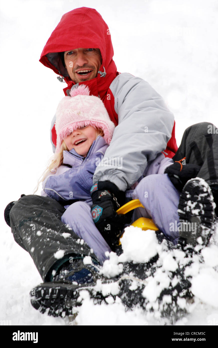 father and daughter sledding in snow Stock Photo - Alamy