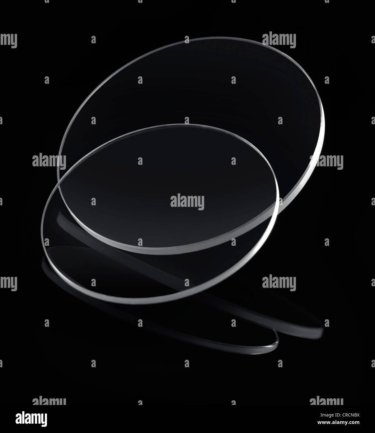 Watch glasses on reflective black underground Stock Photo - Alamy