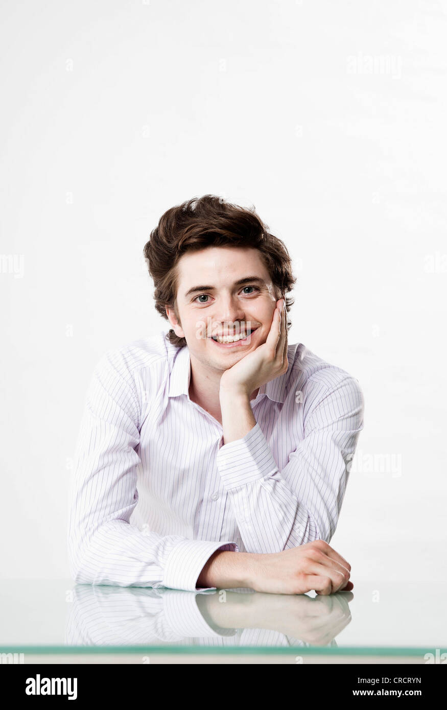 Smiling young man at desk Stock Photo - Alamy