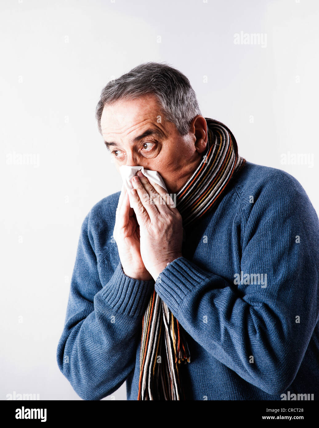 Senior man in winter clothes blowing his nose Stock Photo - Alamy