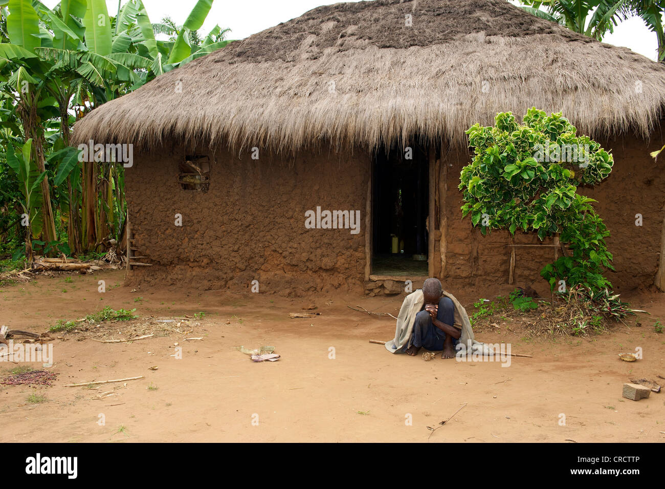 Old man in front of a traditional mud-walled house near Bukoba ...