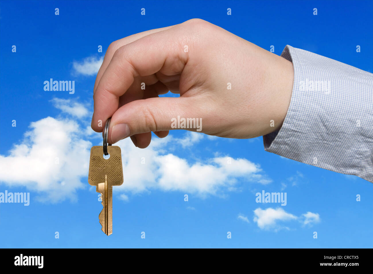 hand with key on blue sky background Stock Photo - Alamy