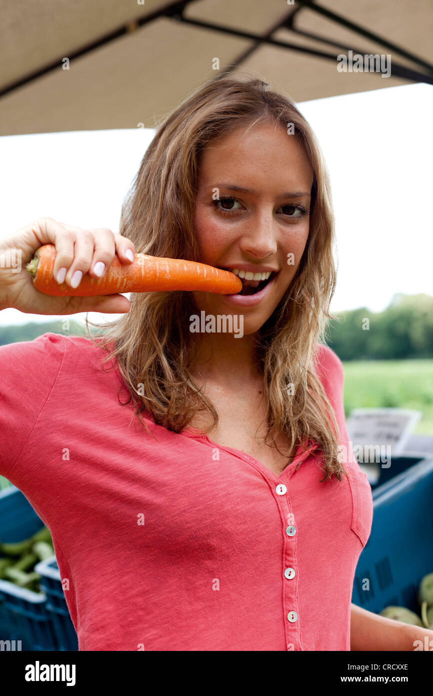 Young woman eating carrot Stock Photo - Alamy