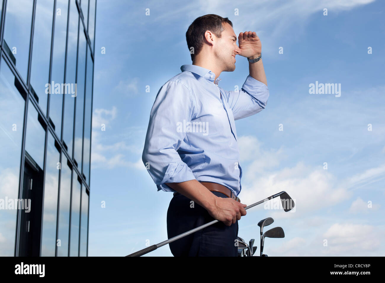 Man with golf club Stock Photo - Alamy