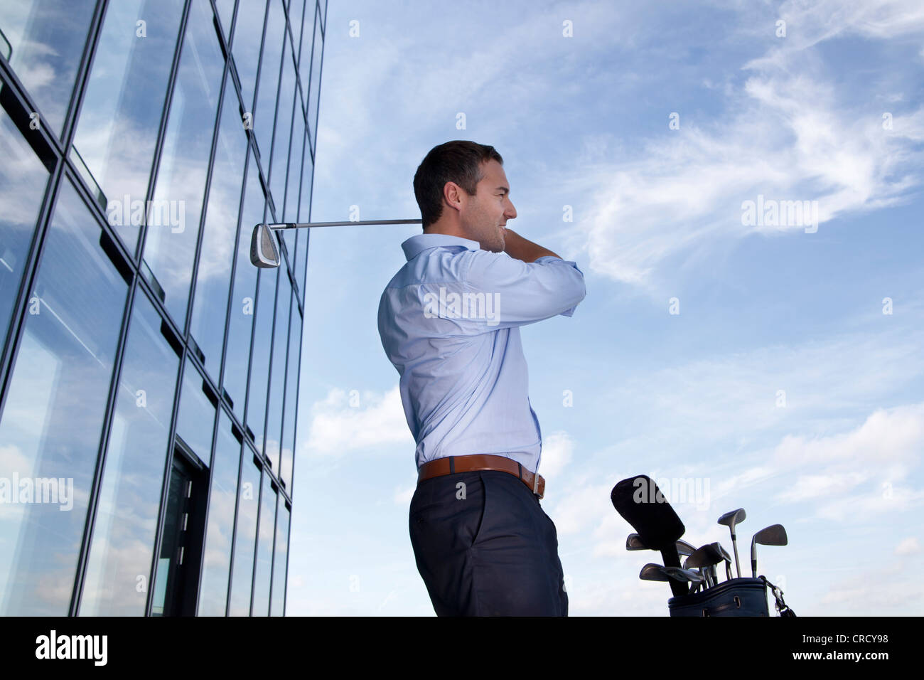 Man with golf club Stock Photo - Alamy