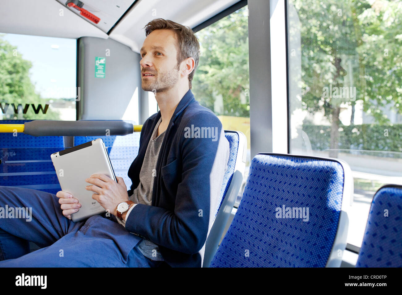 Man with ipad in bus Stock Photo - Alamy