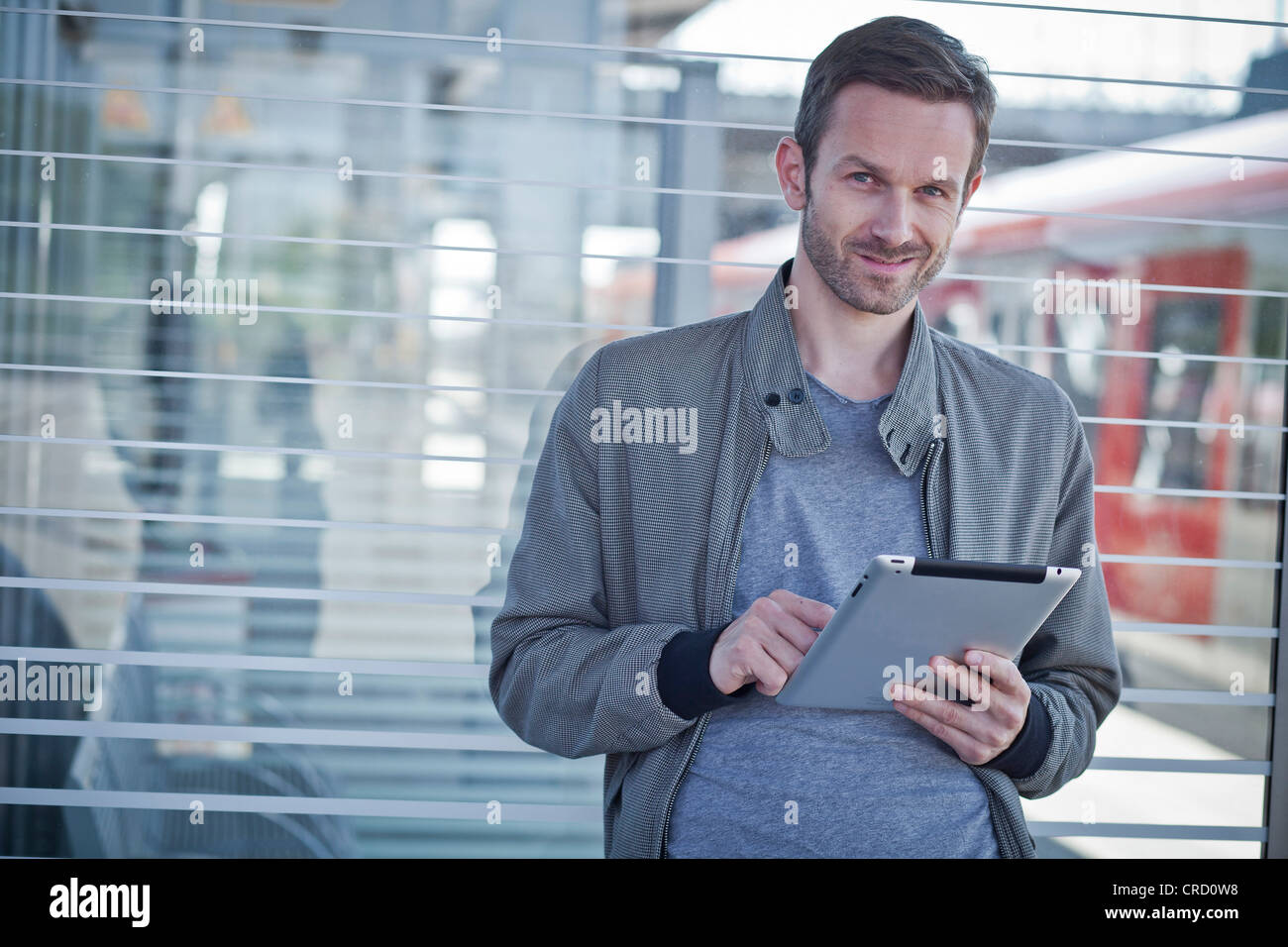 Man with ipad outdoors Stock Photo - Alamy