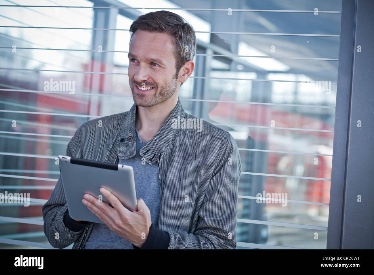 Man with ipad outdoors Stock Photo - Alamy