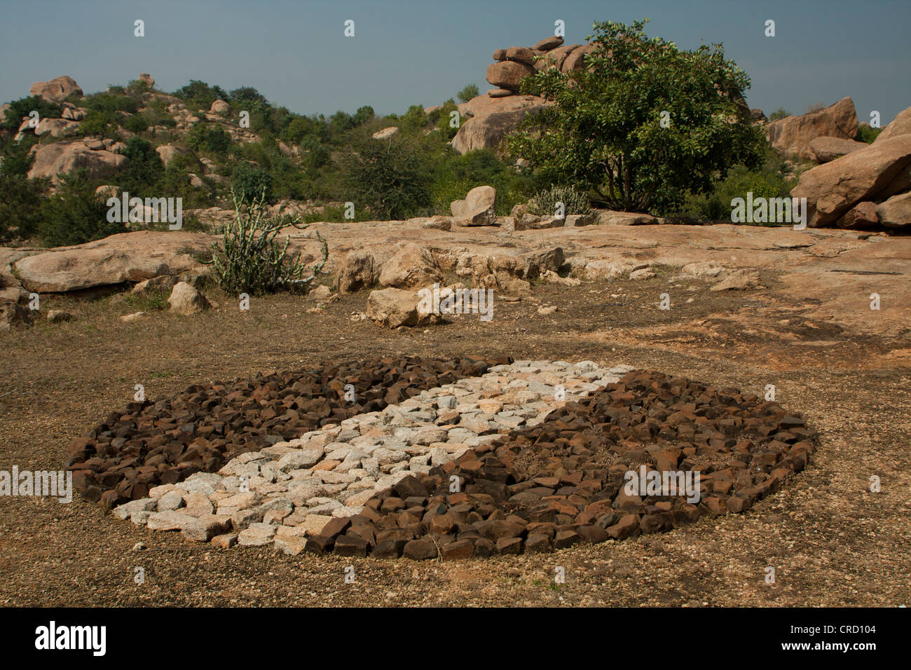 Stone sculpture in barren landscape a brown circle with white line ...