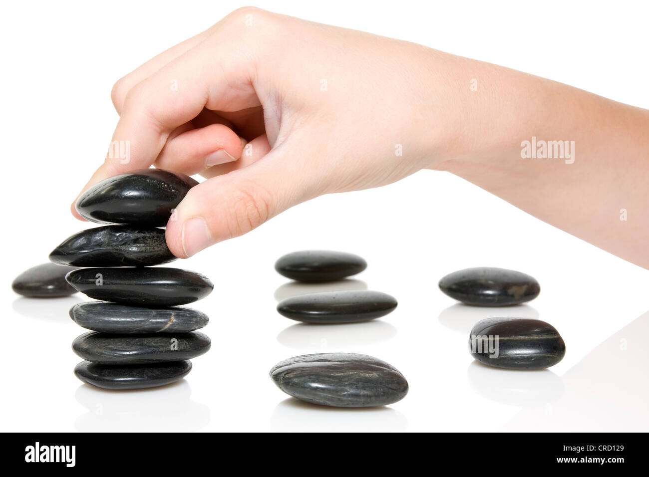 Building a Zen garden. hand and stones on white background Stock Photo ...