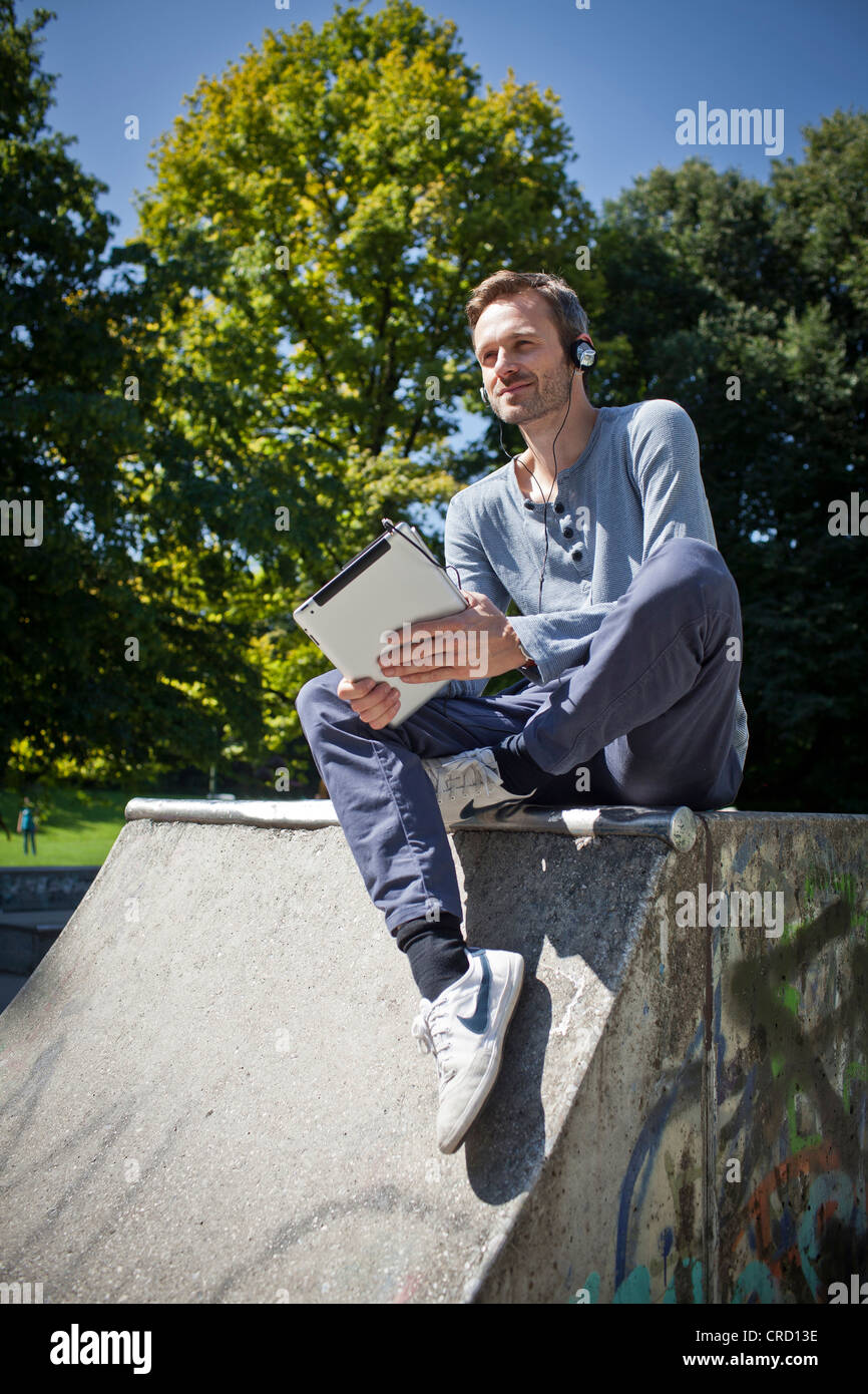 Man with ipad outdoors Stock Photo - Alamy