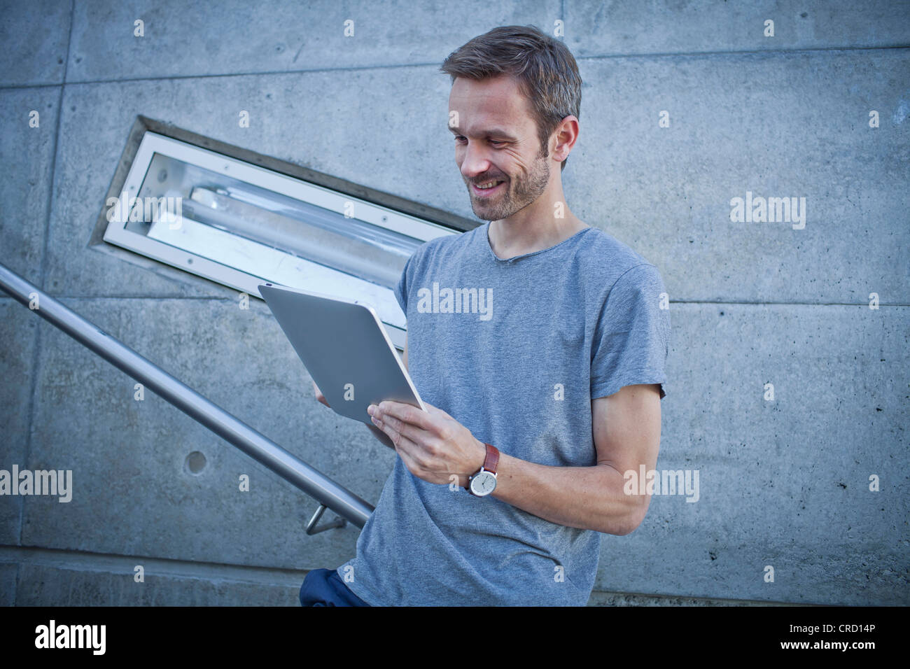 Man with ipad outdoors Stock Photo - Alamy