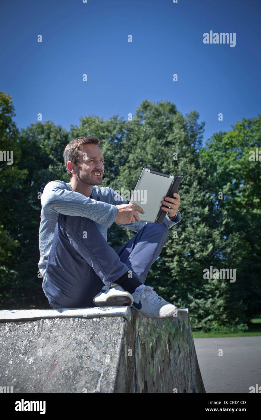 Man with ipad outdoors Stock Photo - Alamy
