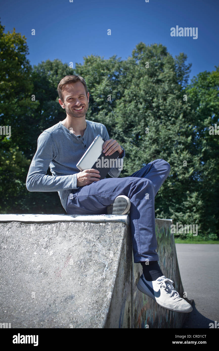 Man with ipad outdoors Stock Photo - Alamy