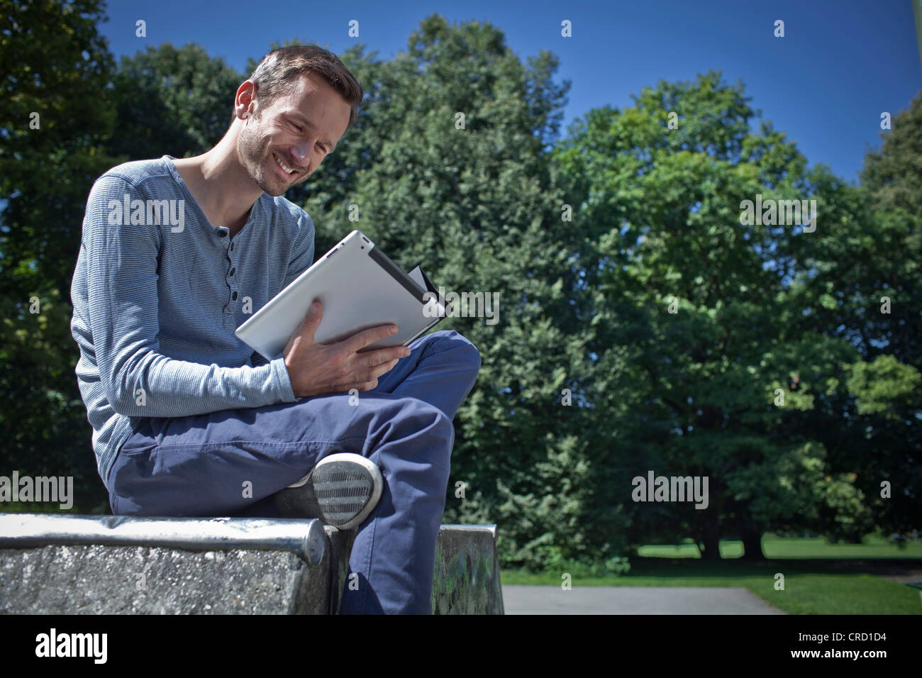 Man with ipad outdoors Stock Photo - Alamy