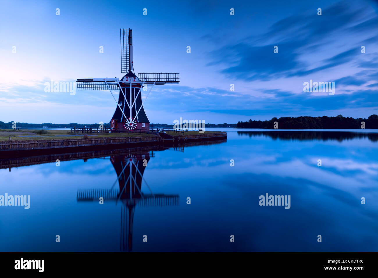 windmill close to lake in dusk Stock Photo - Alamy