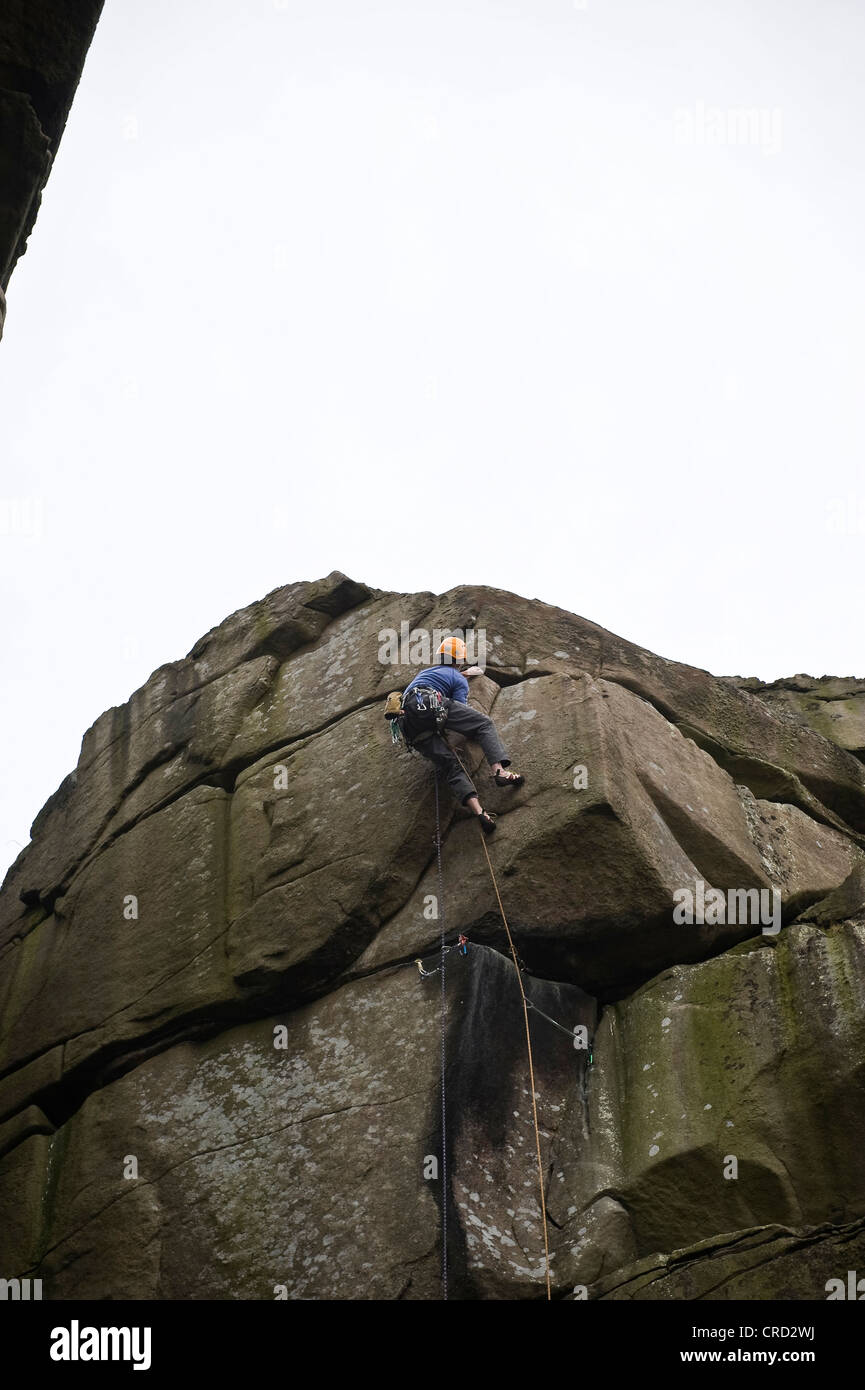 Rock climber on The Crack at Cratcliffe Rocks in the Peak District ...