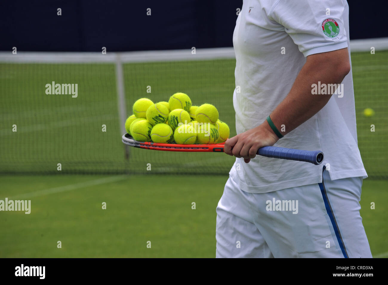 Man carrying tennis balls on his racket Summer 2012 Stock Photo - Alamy