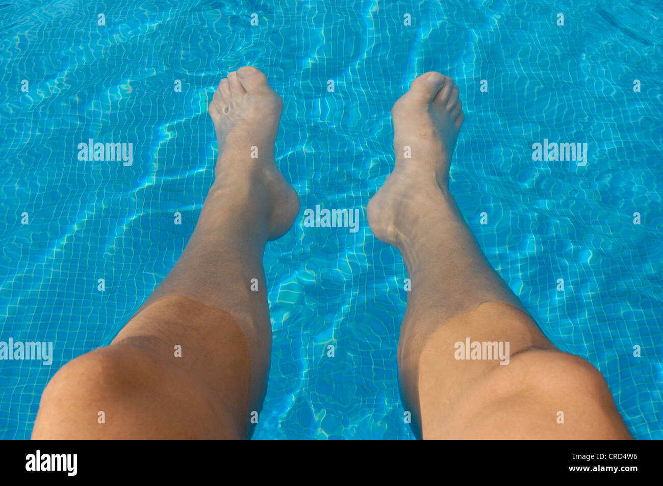 legs of man dangling in a swimming pool Stock Photo - Alamy