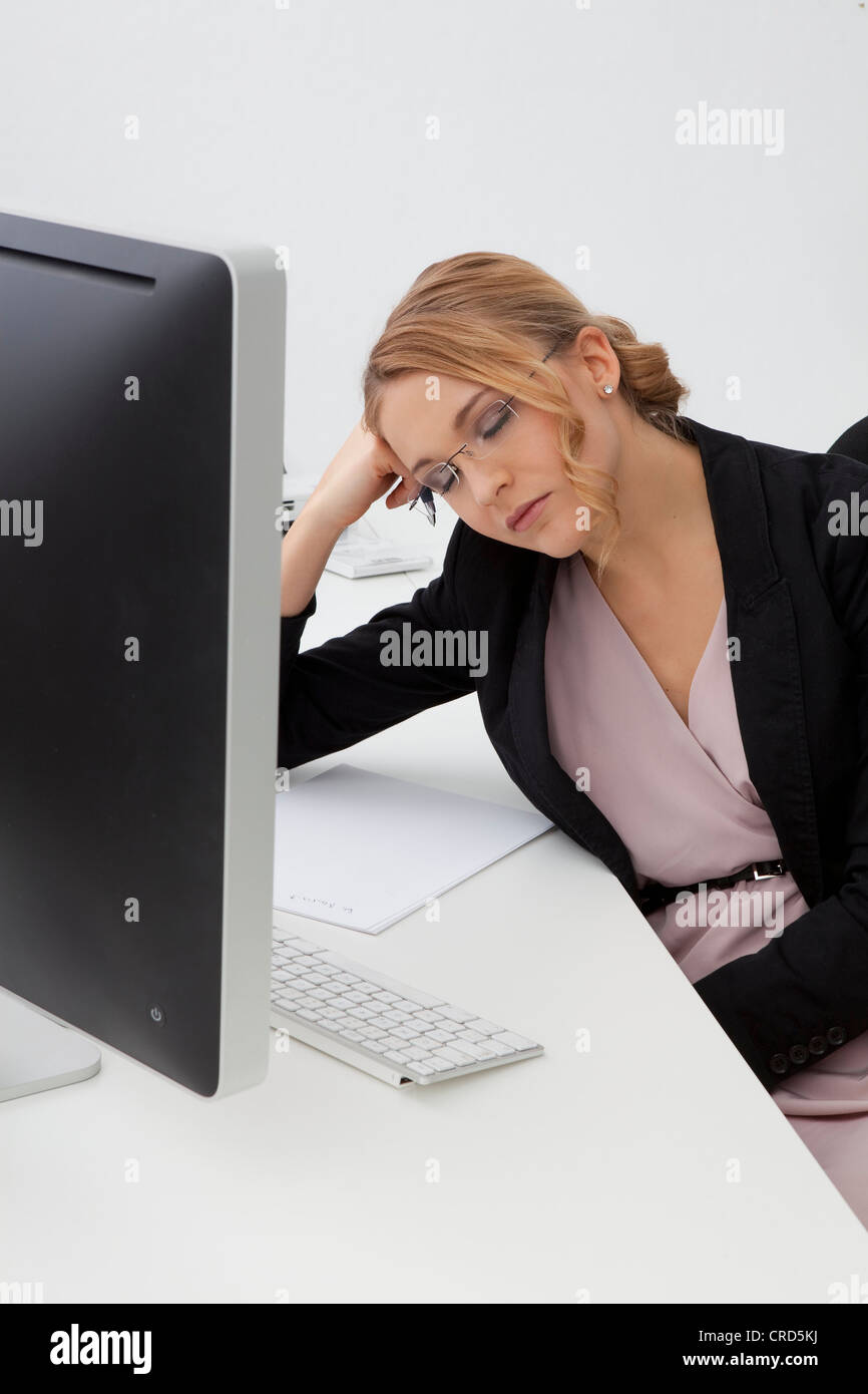 Young woman with closed eyes at desk Stock Photo - Alamy