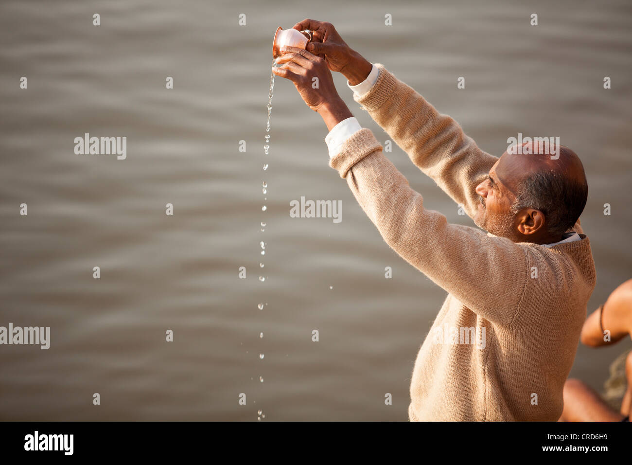 Hindu pilgrims pray with holy water from Ganga river(Ganges), Varanasi ...