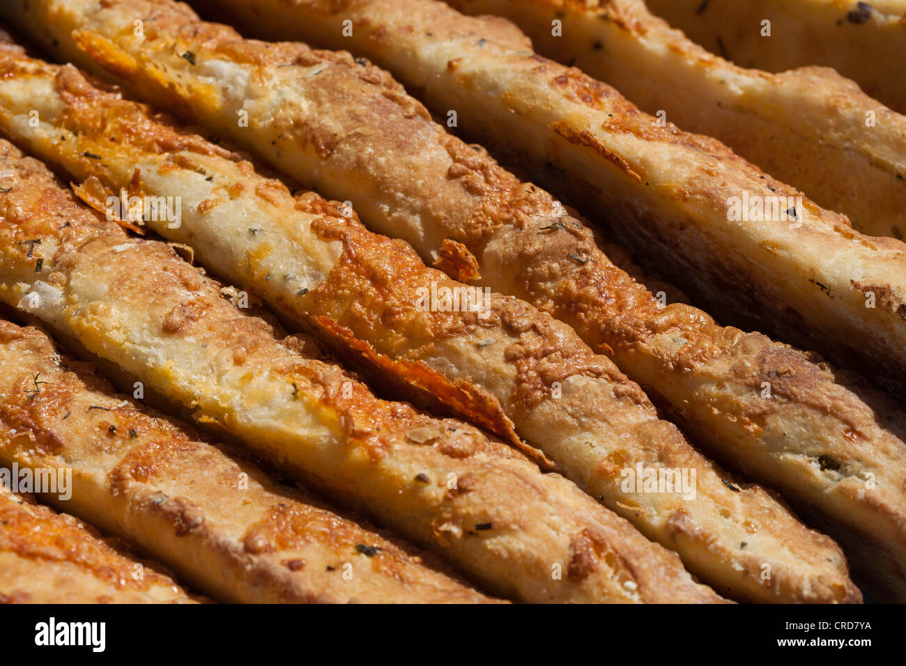 Cheesy bread sticks. Cheese encrusted baguettes of bread at a vendor's ...