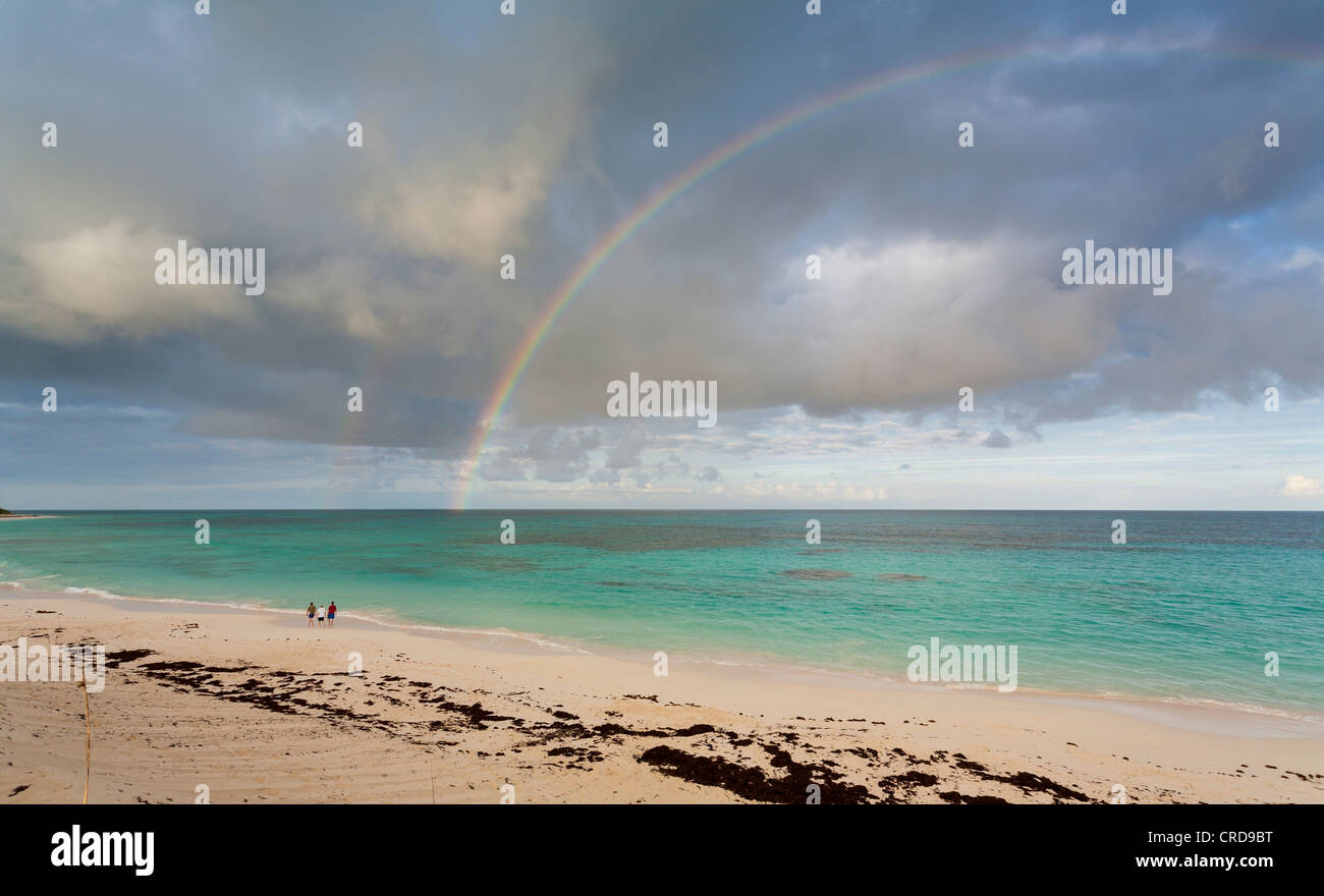 Following the Rainbow. Three men watch a double rainbow off the long ...