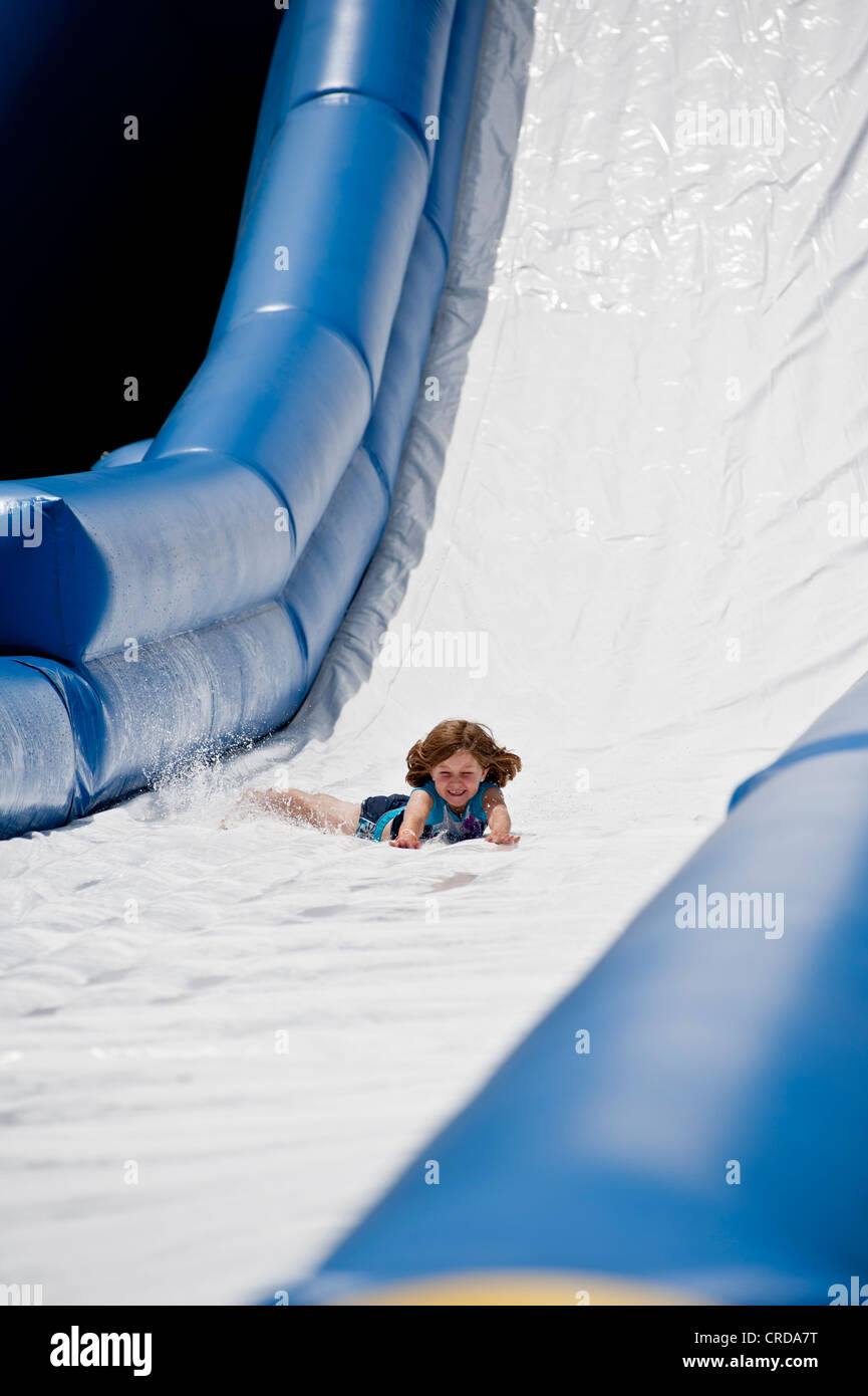Child sliding down inflateable water slide Stock Photo - Alamy